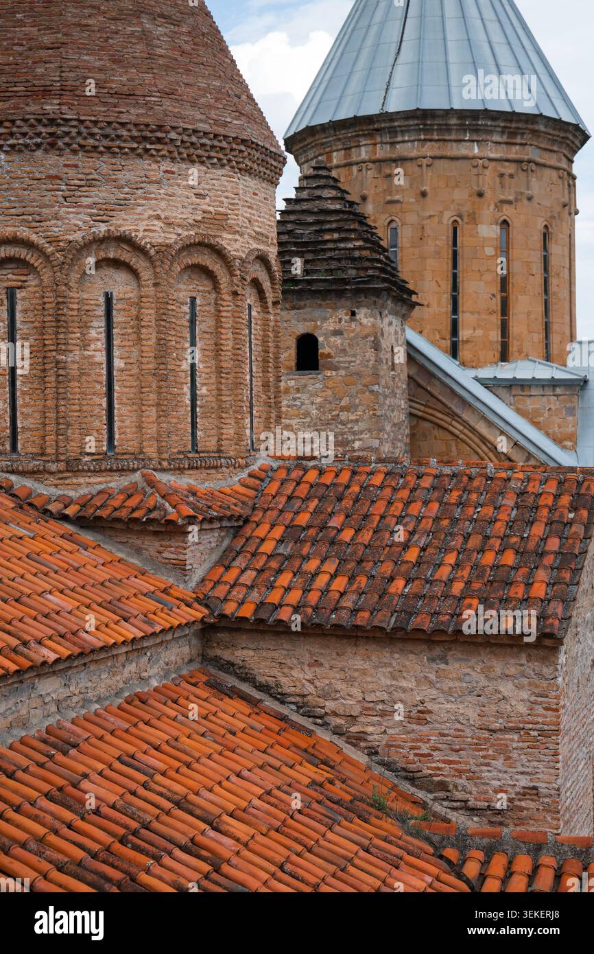 Close-up of traditional orange clay tile roofs and ancient stone church ...