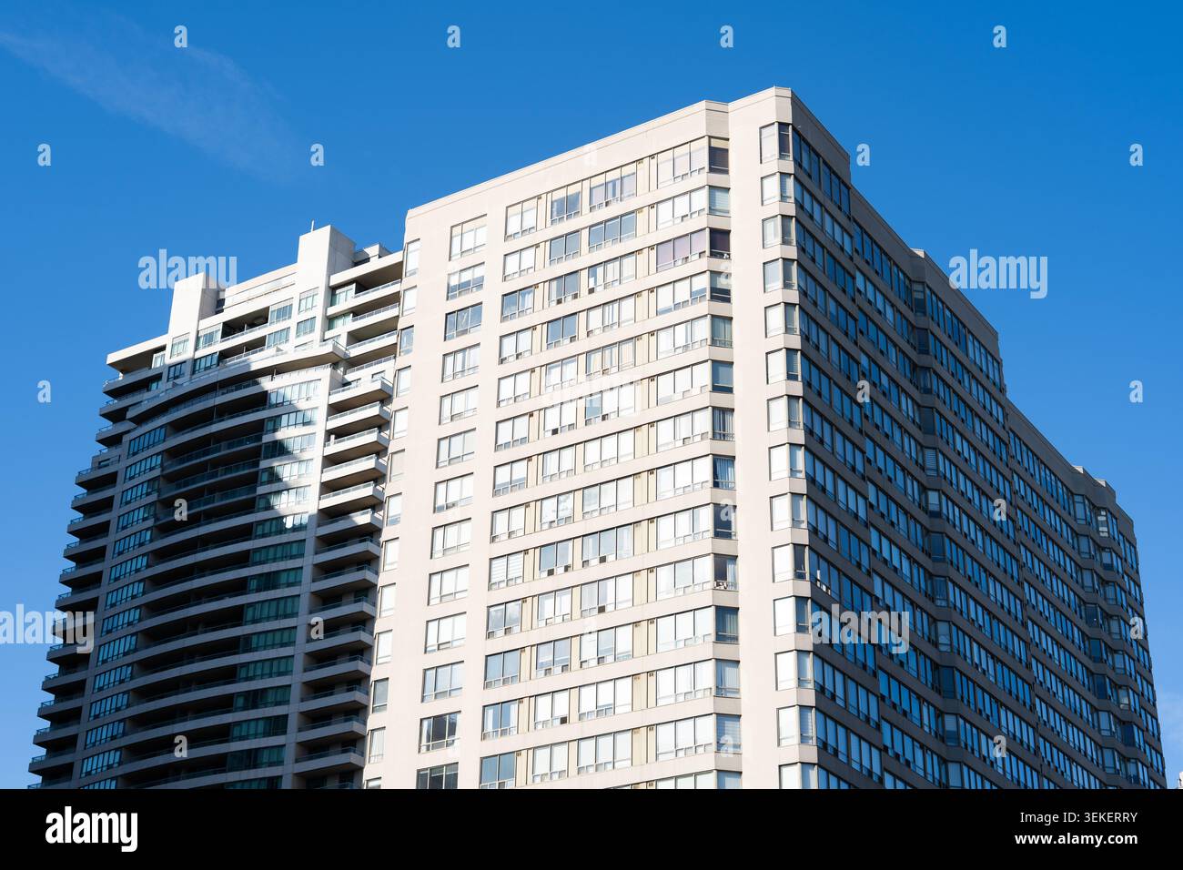 Two modern high rise residential buildings with numerous windows and ...