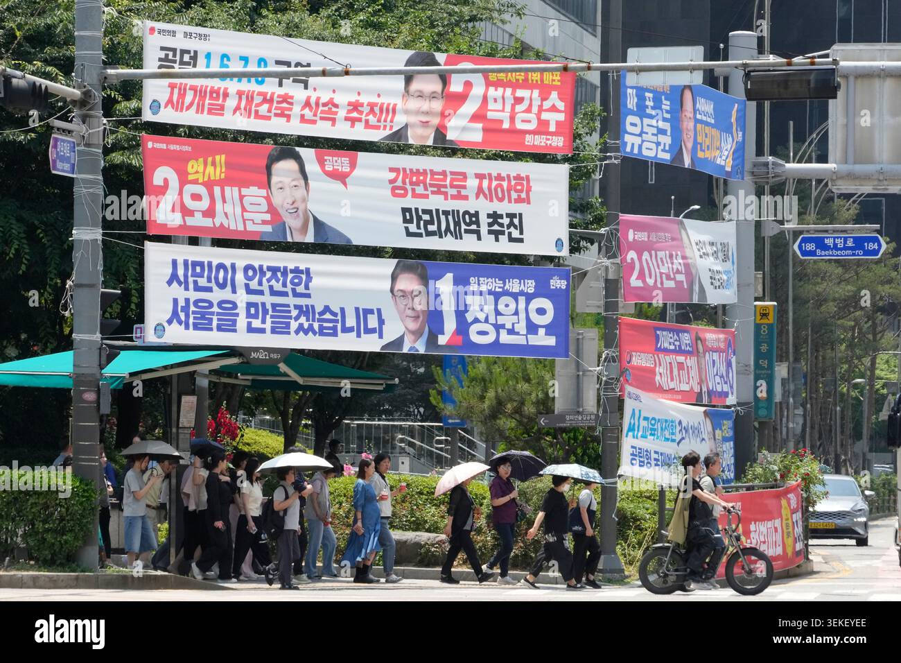 People pass by banners of candidates running for June 3 nationwide ...