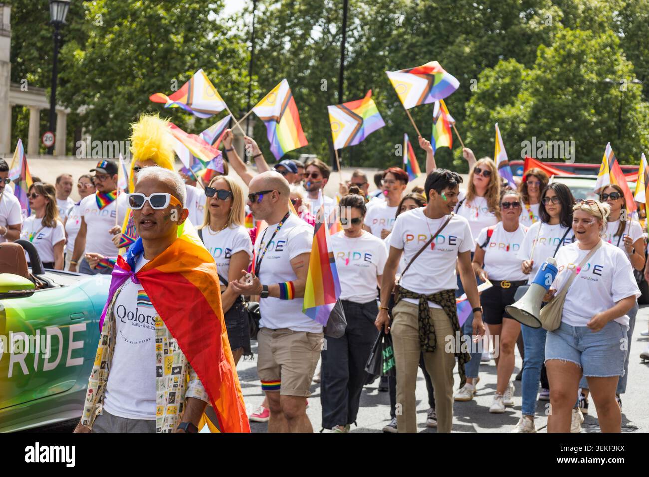 People marching at London Pride parade with rainbow flags and banners ...