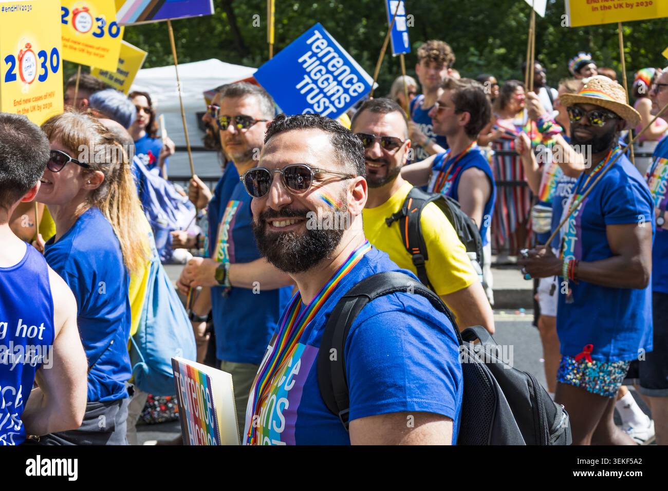 Happy man smiling at London Pride parade with rainbow accessories ...