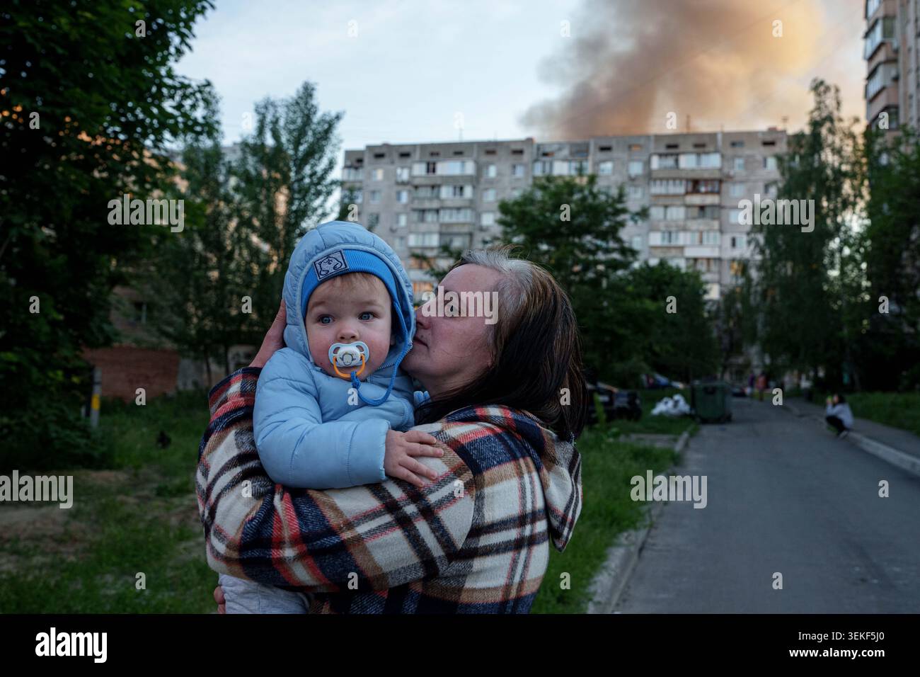 A woman carries a baby near a residential house damaged after a Russian ...