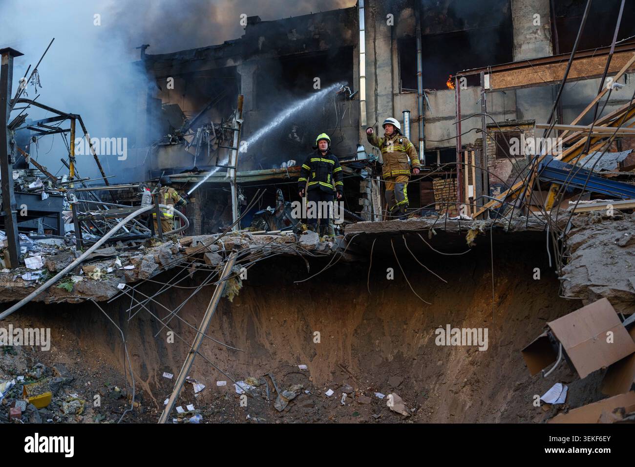 A rescue worker puts out a fire of a building damaged after a Russian ...