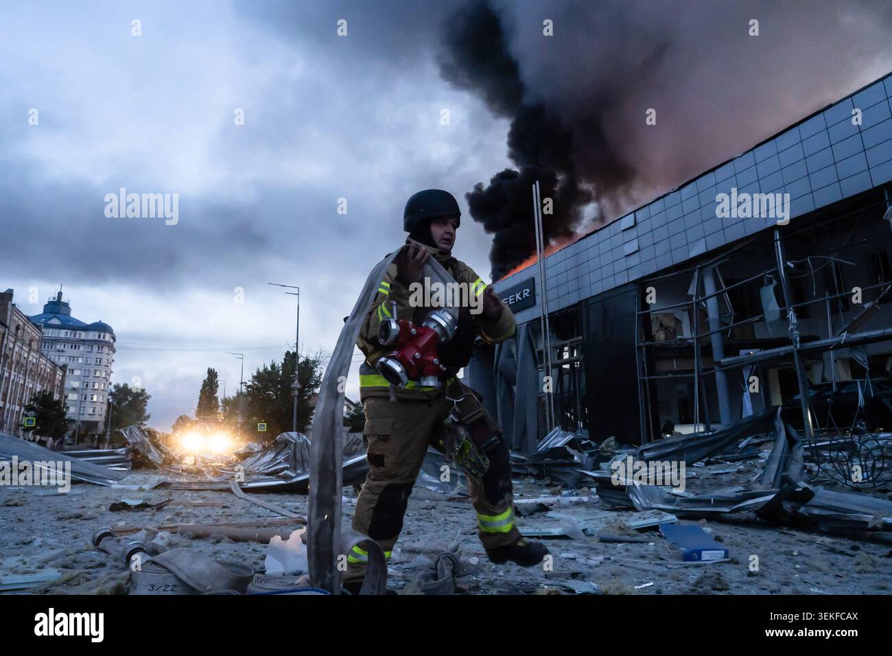 Ukrainian firefighter works to extinguish a burning commercial building ...