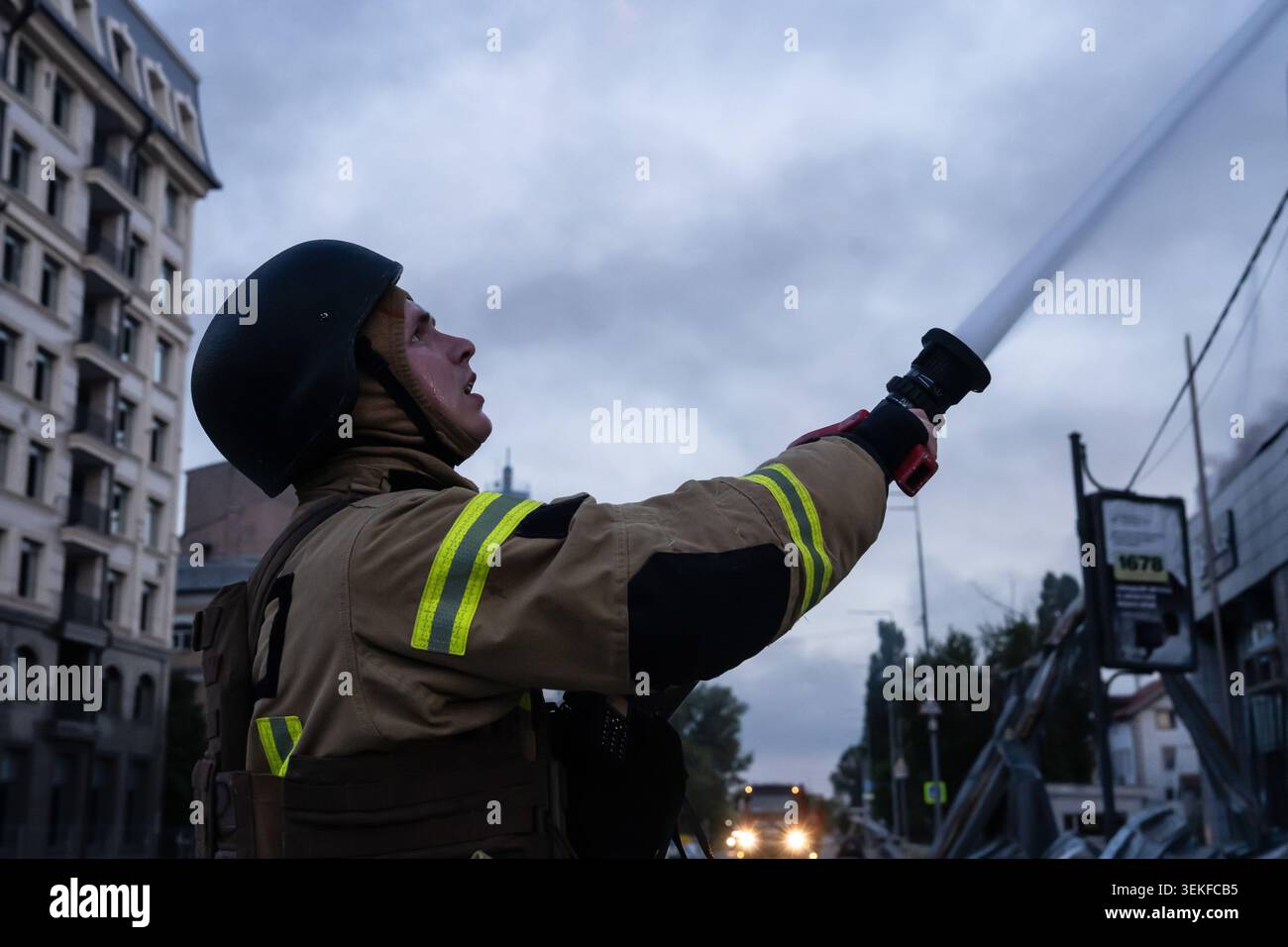 Ukrainian firefighter works to extinguish a burning commercial building ...