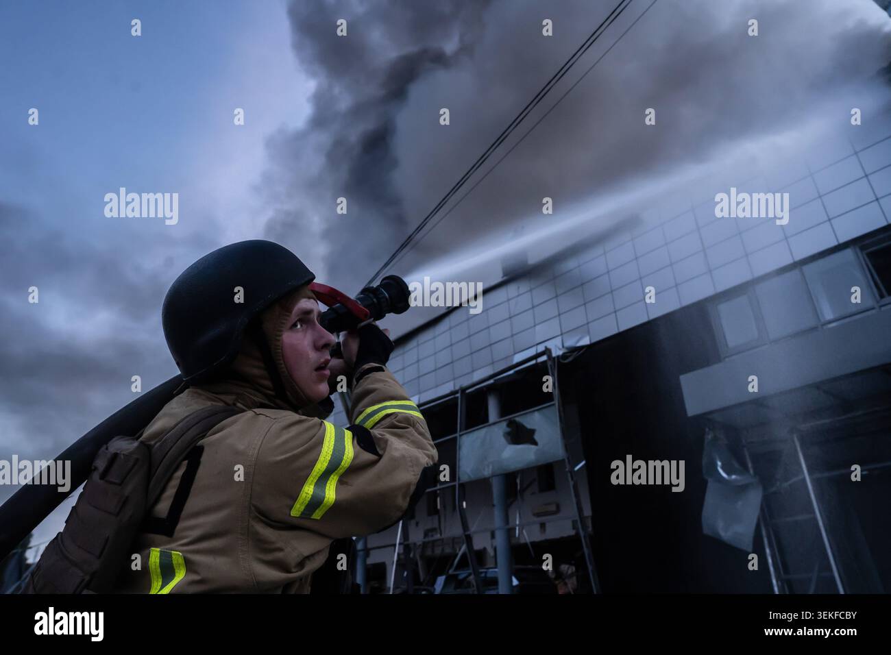 Ukrainian firefighter works to extinguish a burning commercial building ...