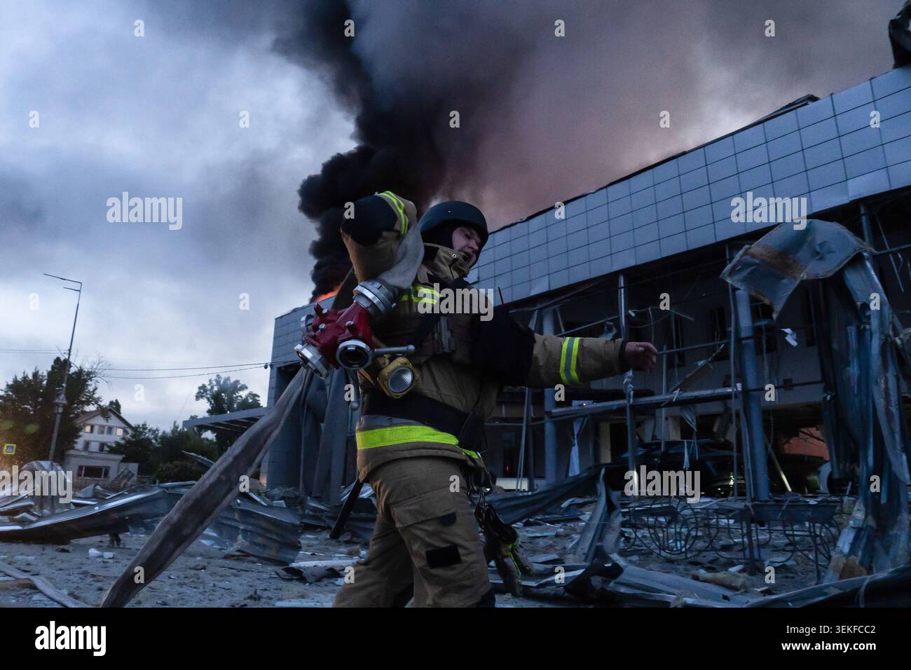 Ukrainian firefighter works to extinguish a burning commercial building ...
