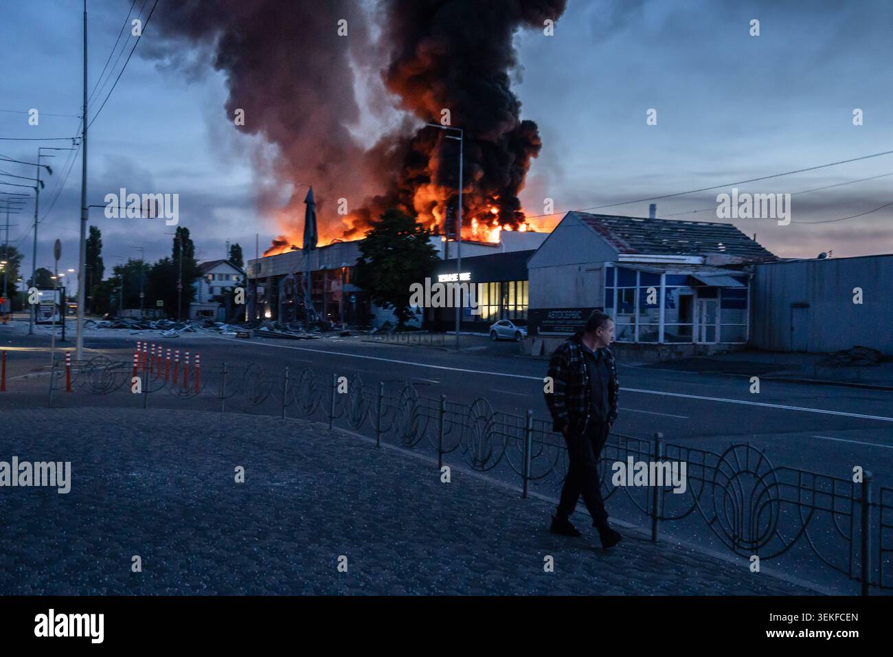 A man walks pass by a burning building after Russian missile and drone ...