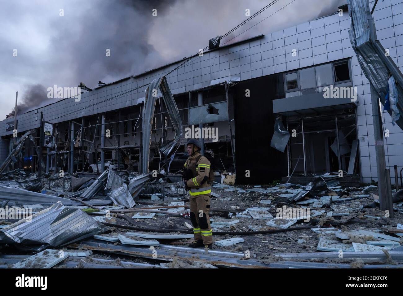 Ukrainian firefighter stands in front of a commercial building damaged ...
