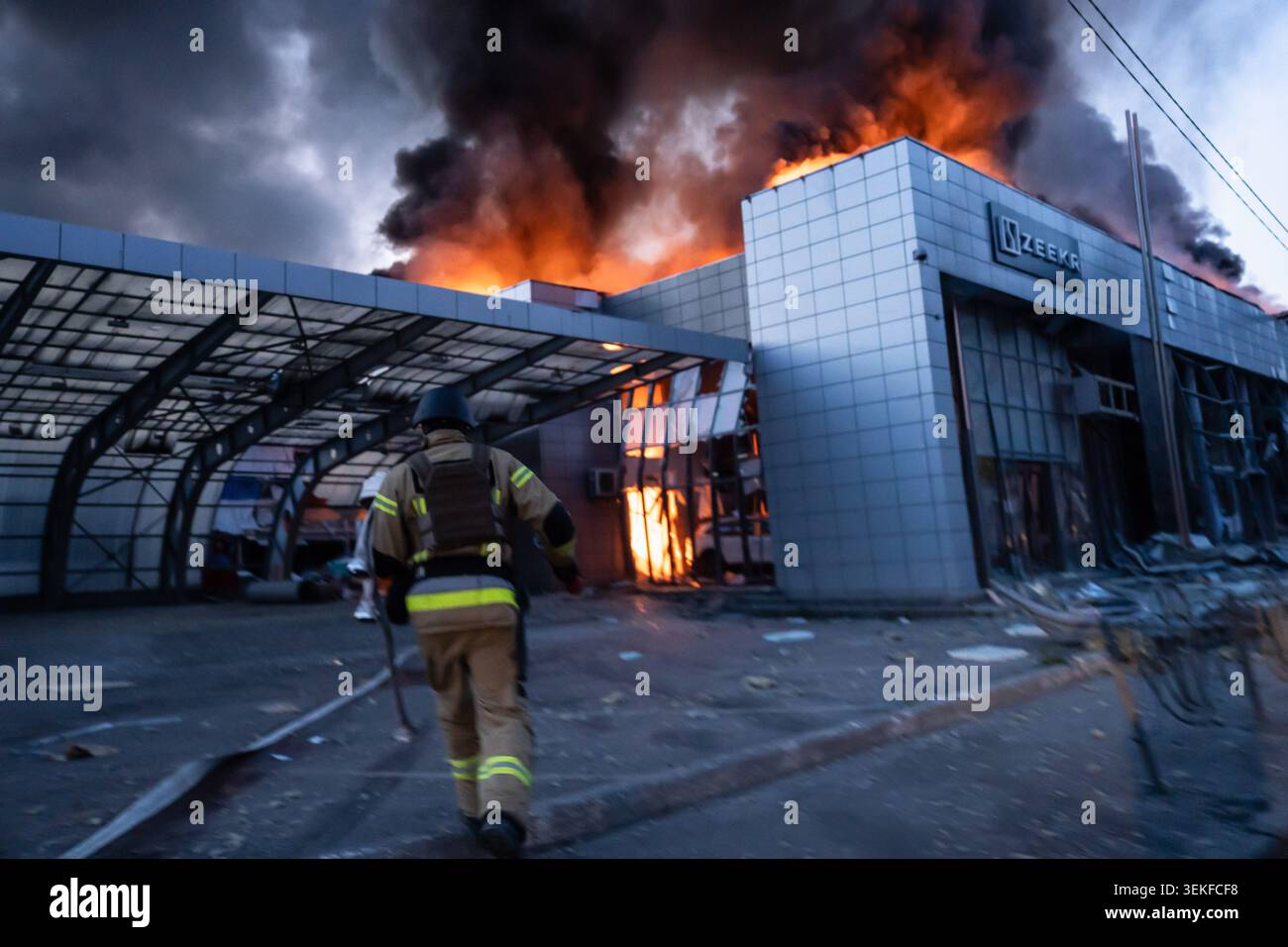 Ukrainian firefighter runs to extinguish a burning building damaged ...