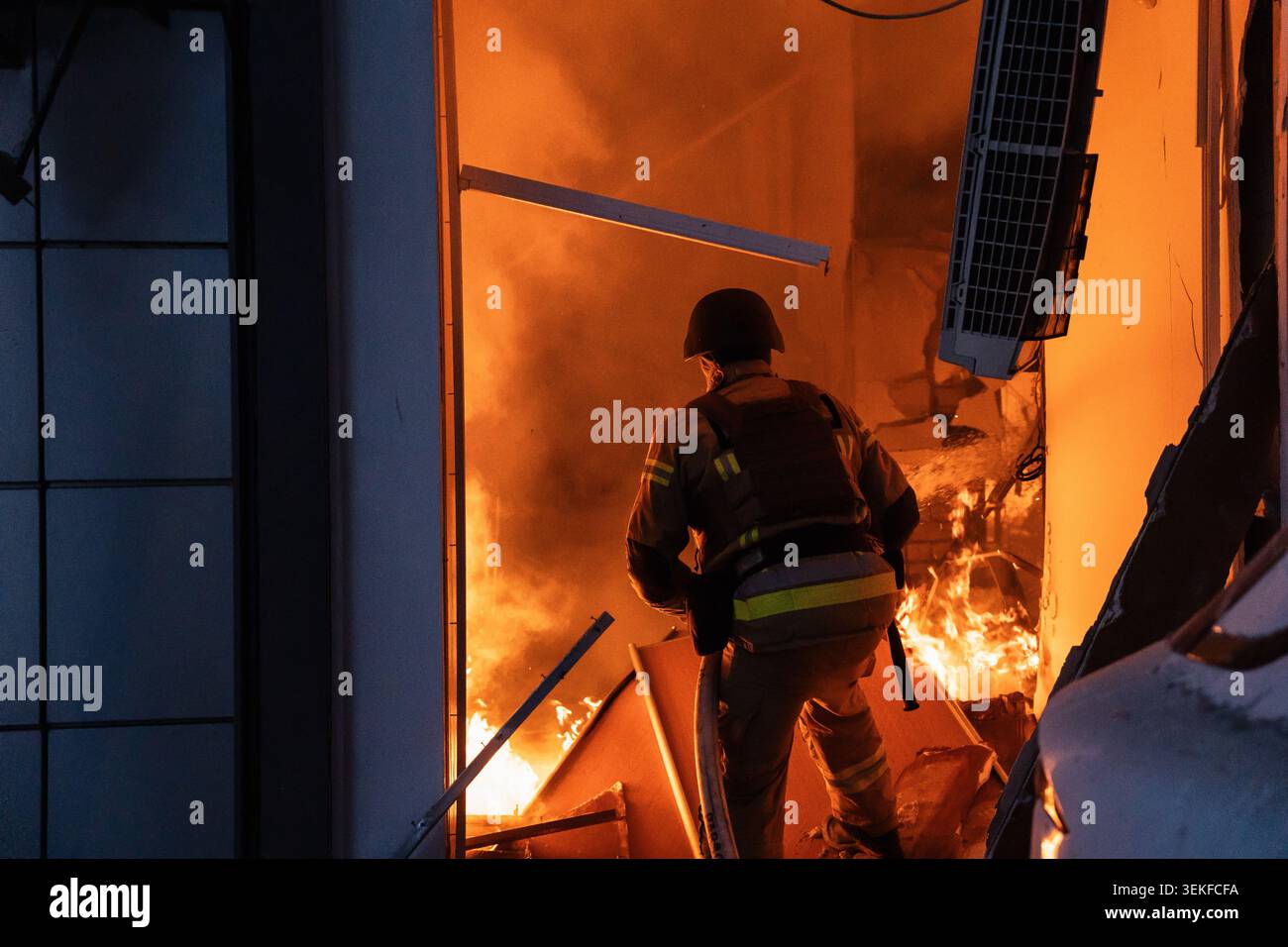 Ukrainian firefighter works to extinguish a burning commercial building ...