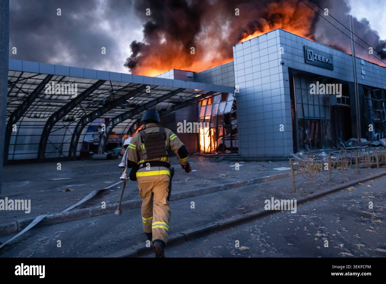 Ukrainian firefighter runs to extinguish a burning building damaged ...