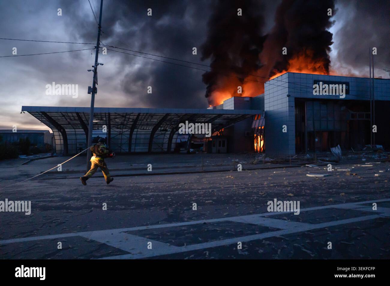Ukrainian firefighter runs to extinguish a burning building damaged ...