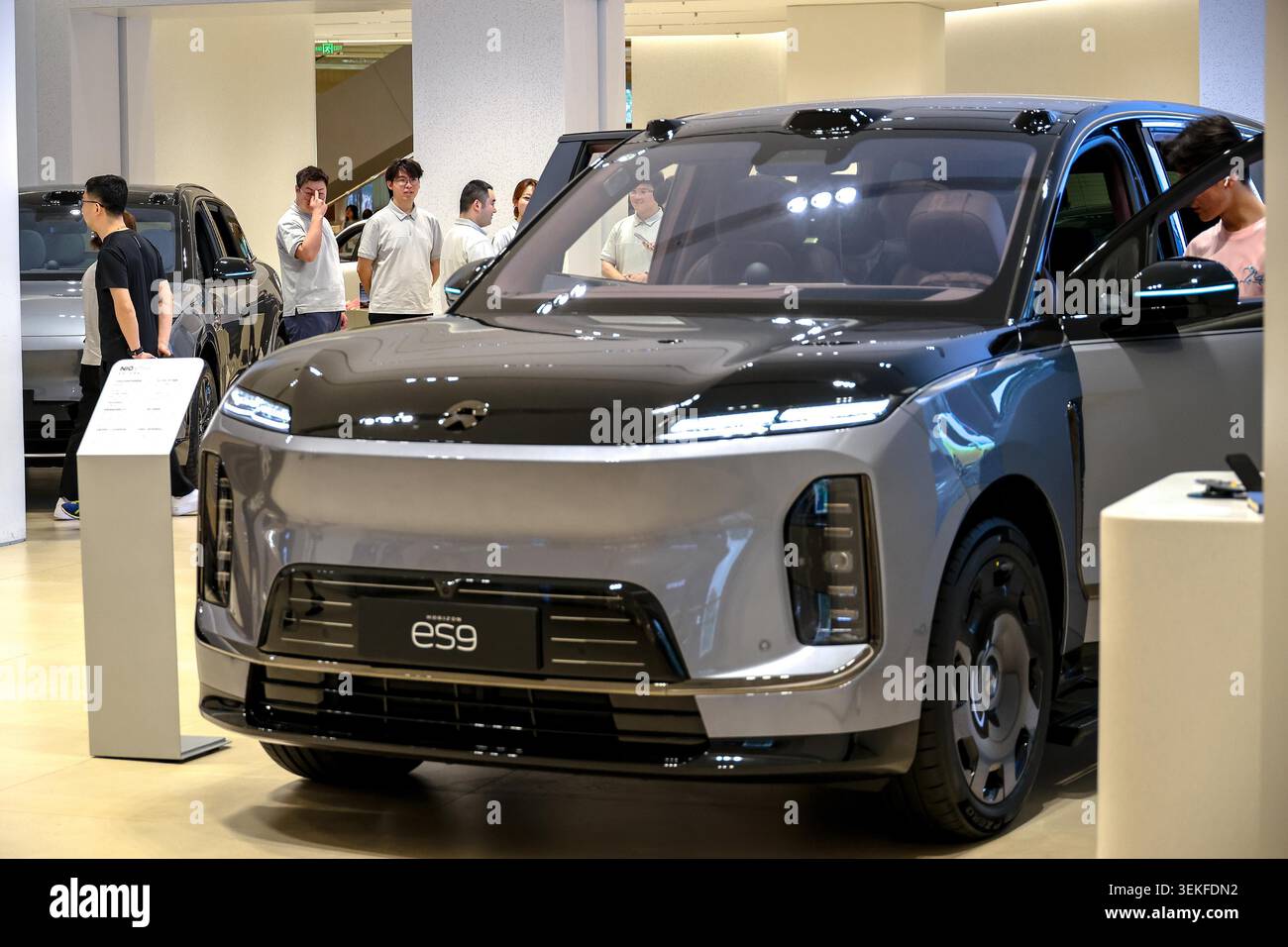 A car buyer tries a NIO new energy vehicle at a shopping mall in ...