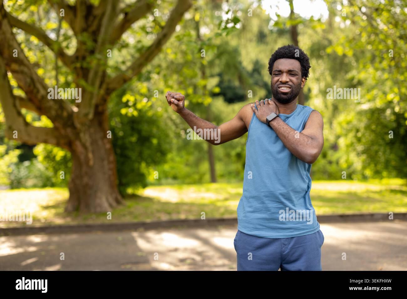 Athletic man experiencing sharp shoulder pain while exercising in a ...
