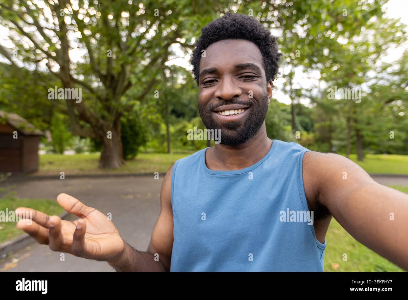Happy man smiling broadly, extending his arm to take a selfie in a ...