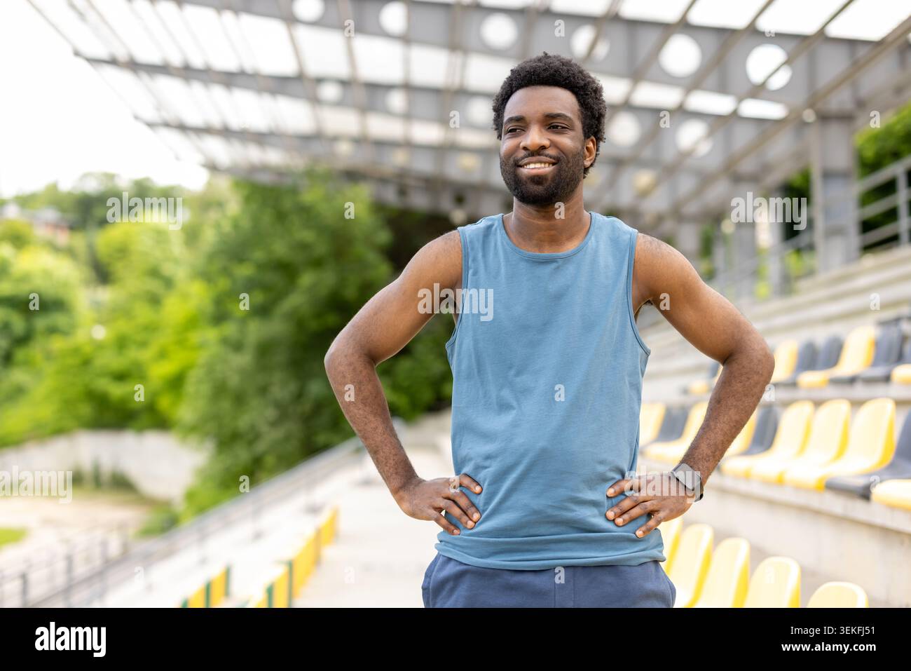 Smiling african ethnicity man wearing a sports tank top, standing with ...