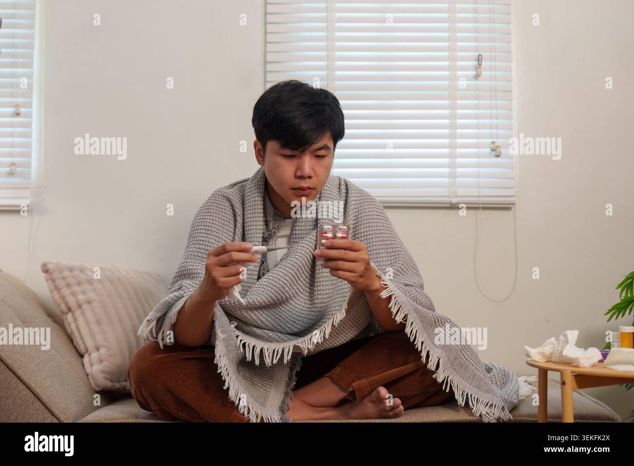 Asian man holding thermometer and water with pills for sickness Stock ...
