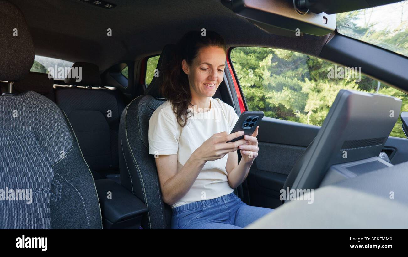 Woman using smartphone inside a car Stock Photo - Alamy
