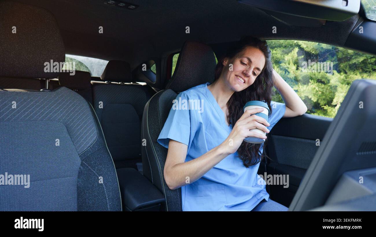 Nurse with a reusable cup taking a break in a vehicle Stock Photo - Alamy