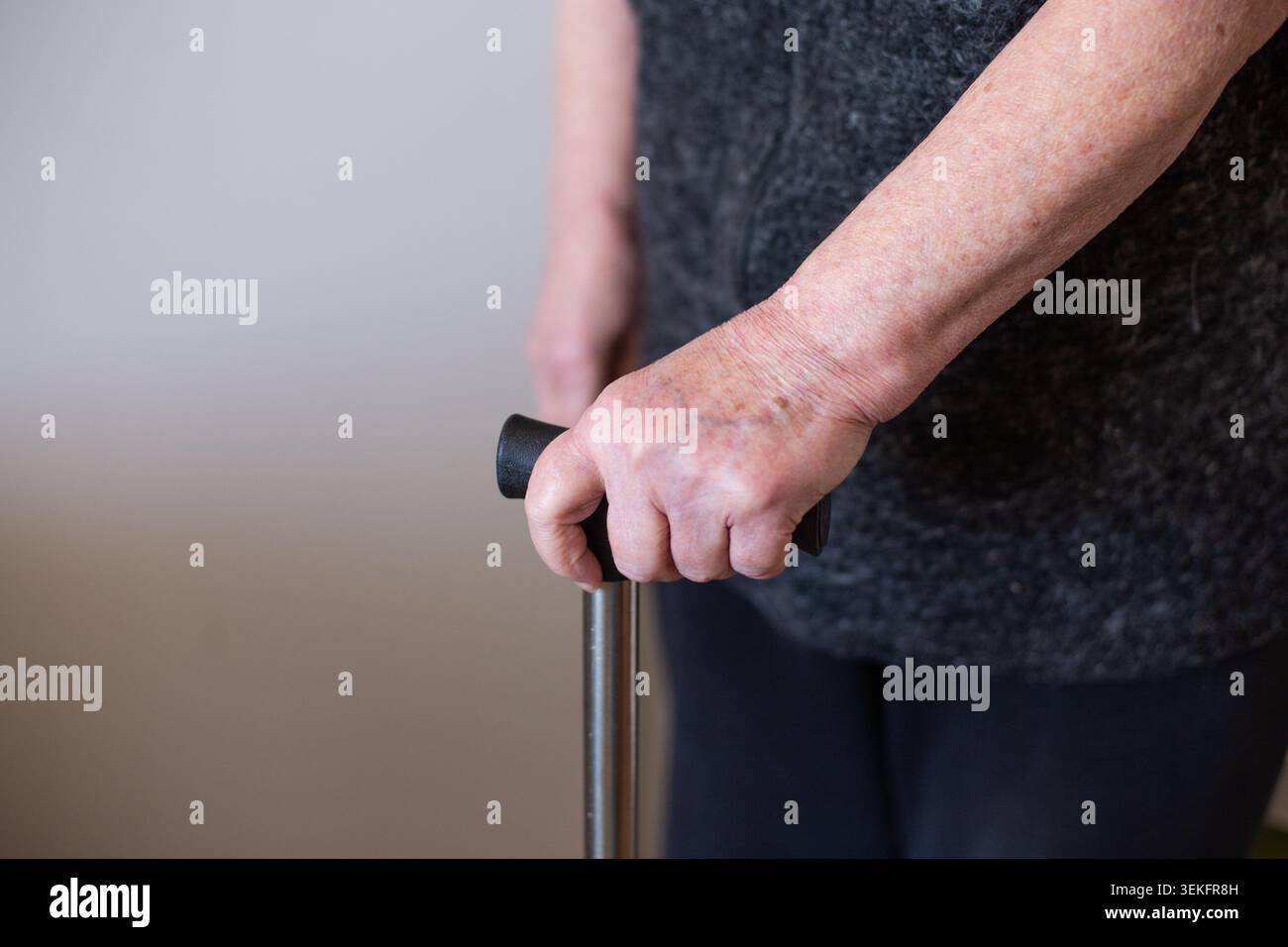 Senior person hand grasping a walking stick, symbolizing support ...