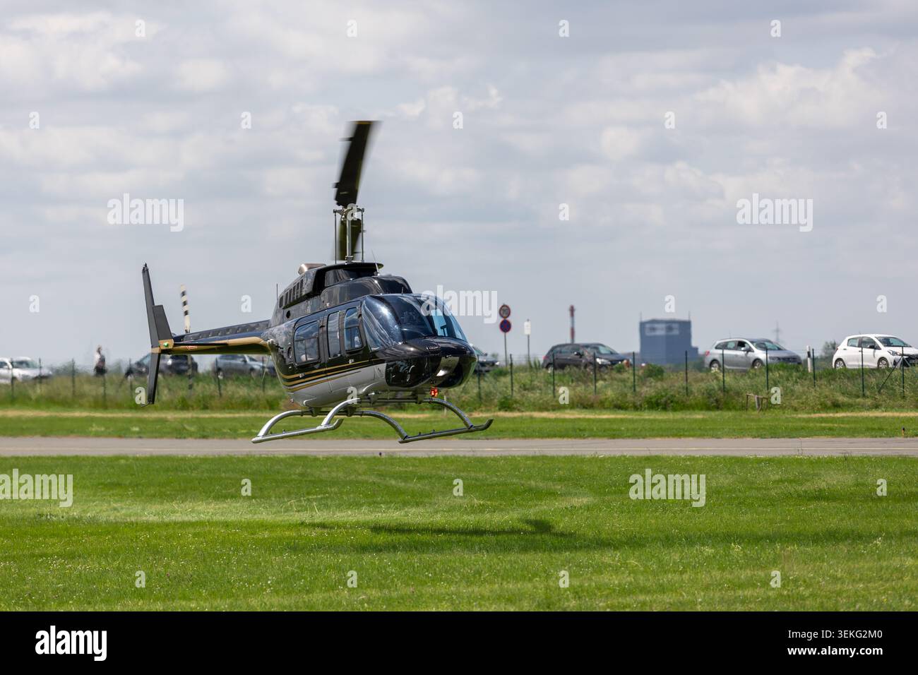 Luxury helicopter hovering above airfield grass spinning rotor blades ...