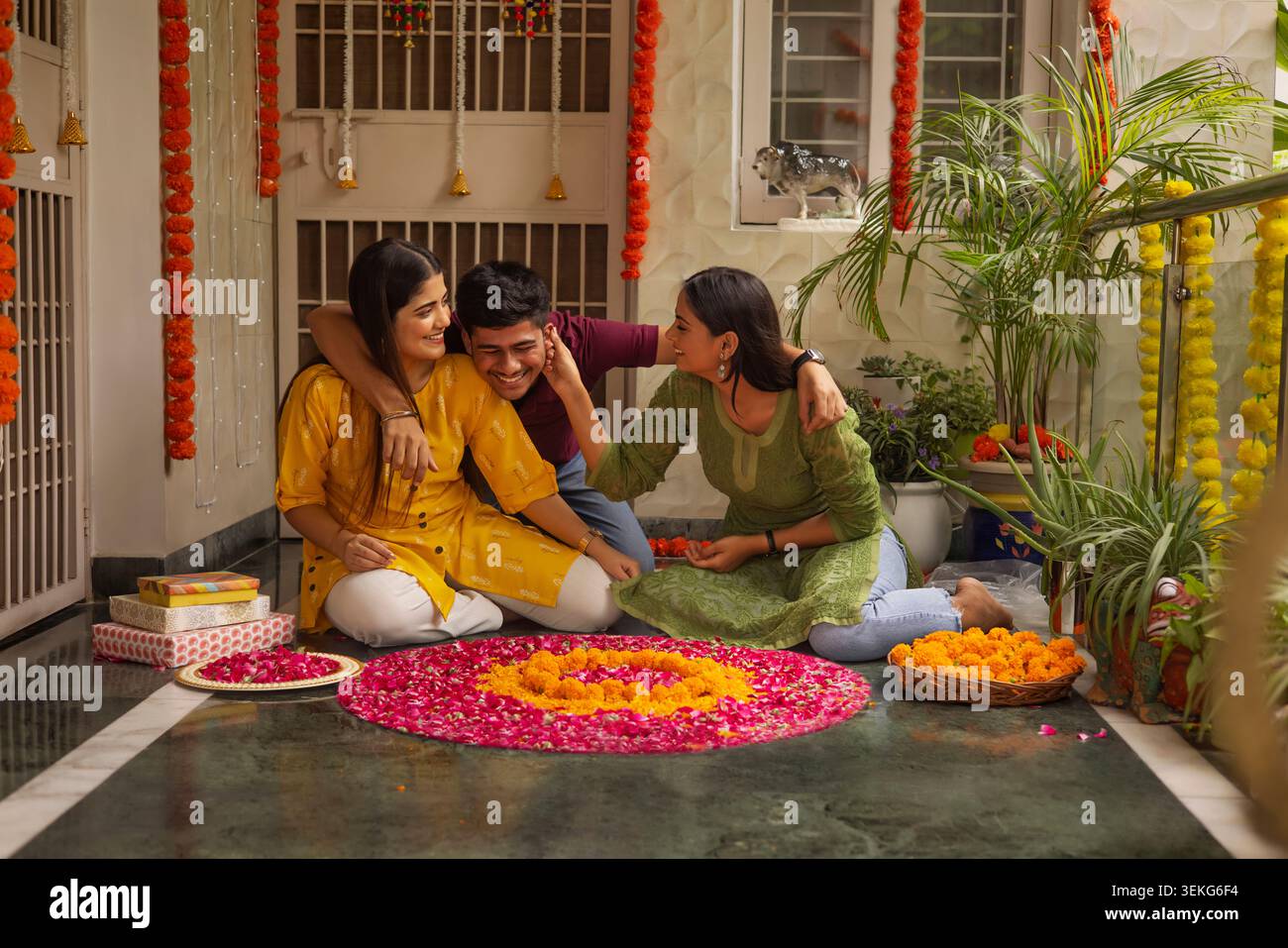 Brother and sisters having fun during floral decoration on the occasion ...