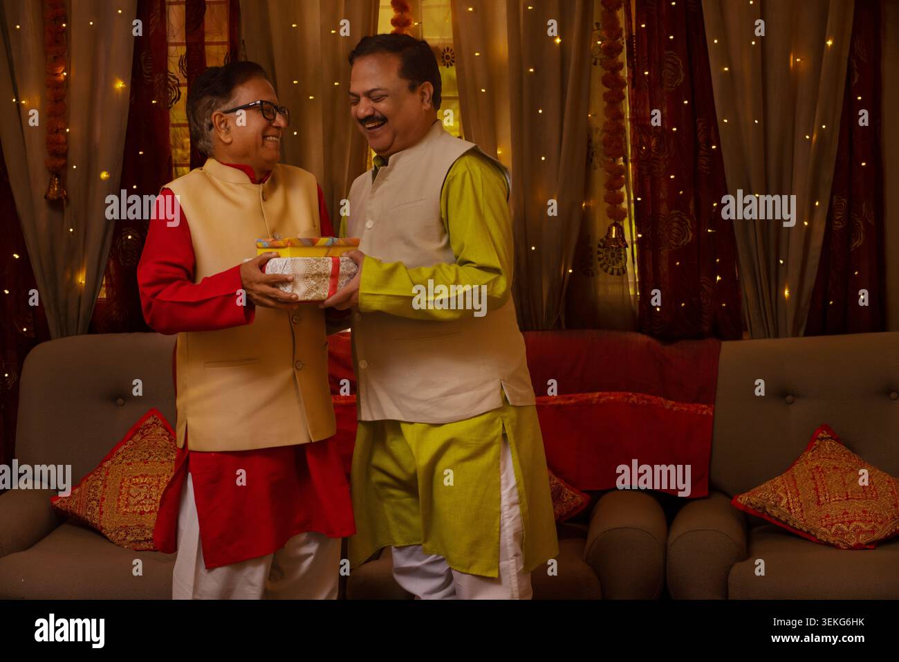Father and son in traditional outfit exchanging gifts during Diwali ...