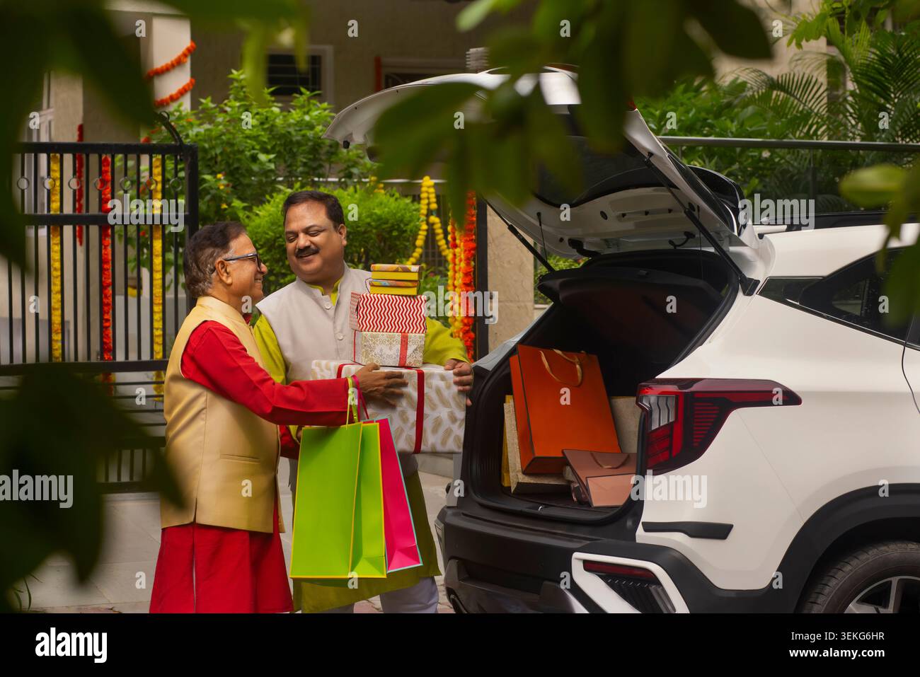 Father and son unloading Diwali gifts from car trunk after shopping ...