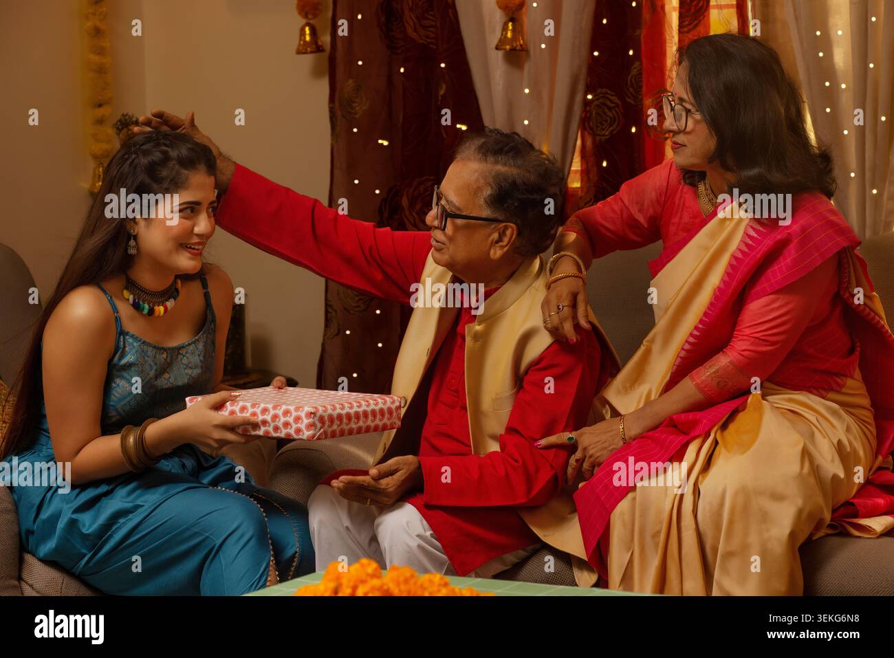 Grandparents and granddaughter sharing gift during Diwali festival ...