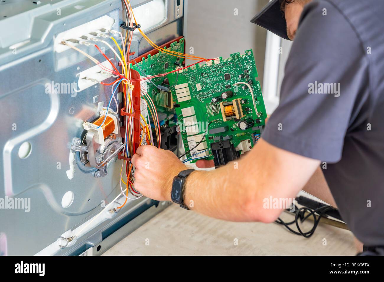 Appliance technician replacing faulty electronic control board inside ...