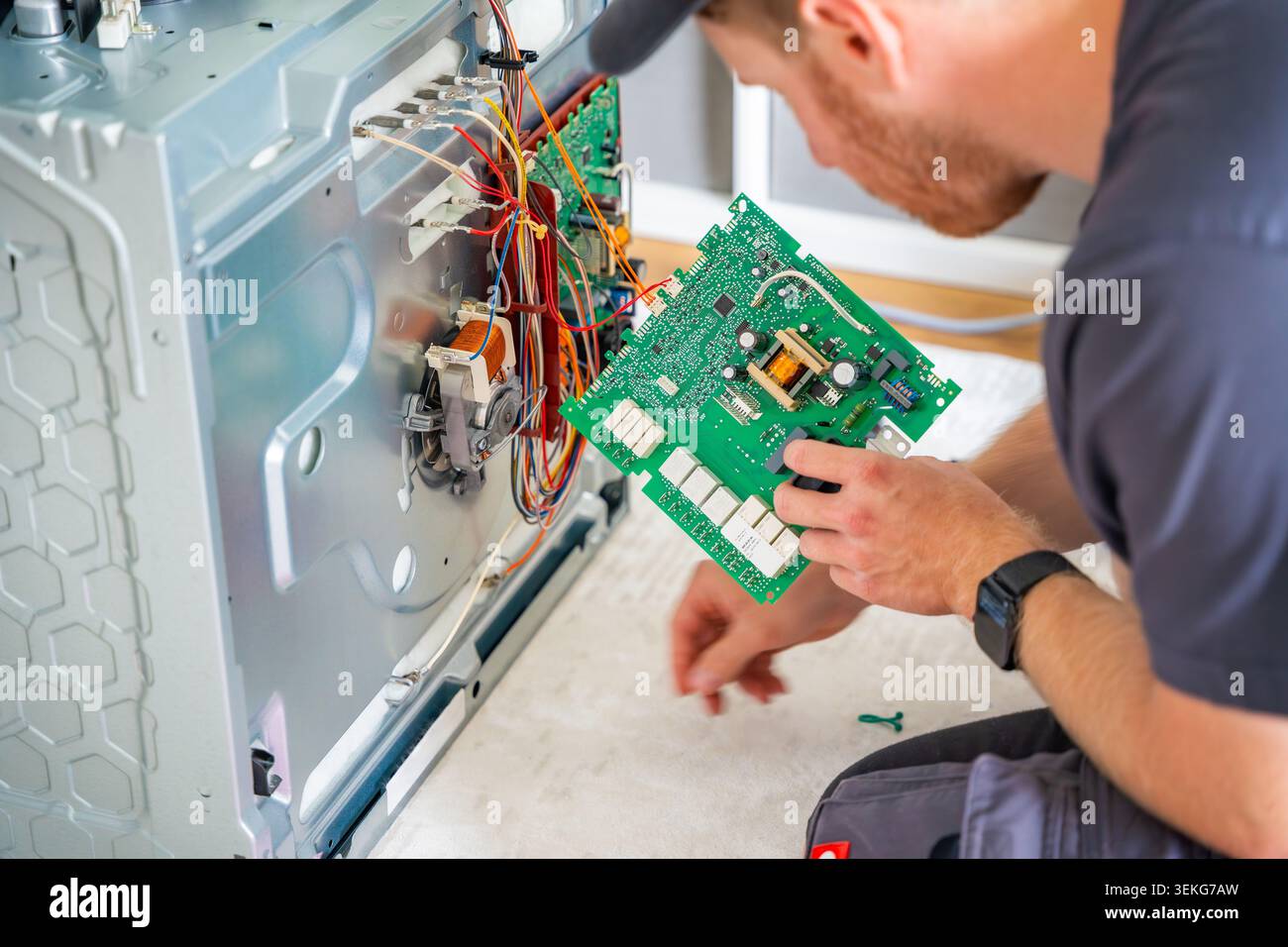 Technician replacing electronic control board inside disassembled ...