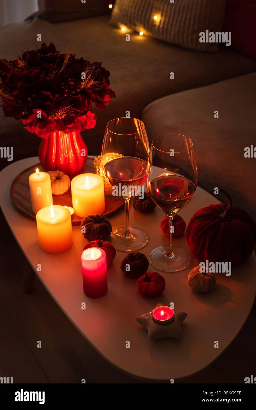 Cozy evening scene with candles, white wine glasses and warm candle ...