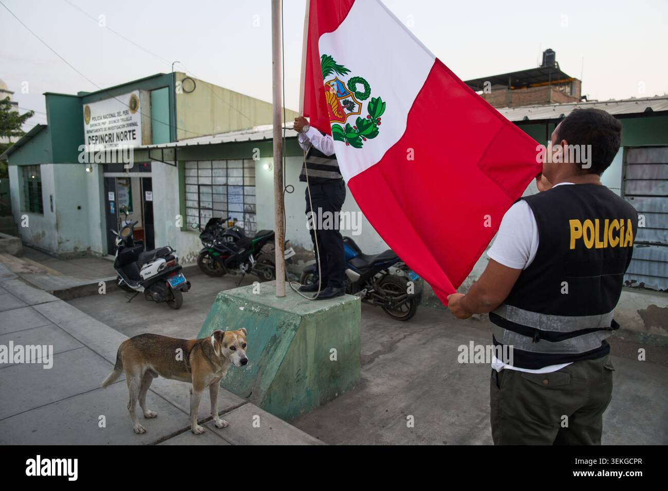 Police officers raise the Peruvian flag outside a criminal ...