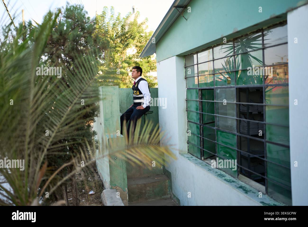 An officer guards an investigative police unit in Trujillo, Peru ...