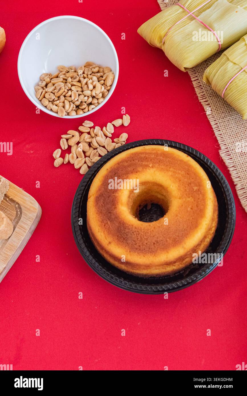 Overhead shot features ring cake on black plate, bowl with peanuts and ...