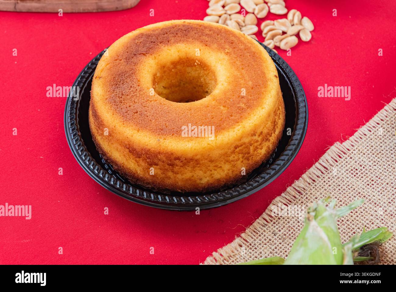 Delicious corn cake on a black plate, presented on a vibrant red ...