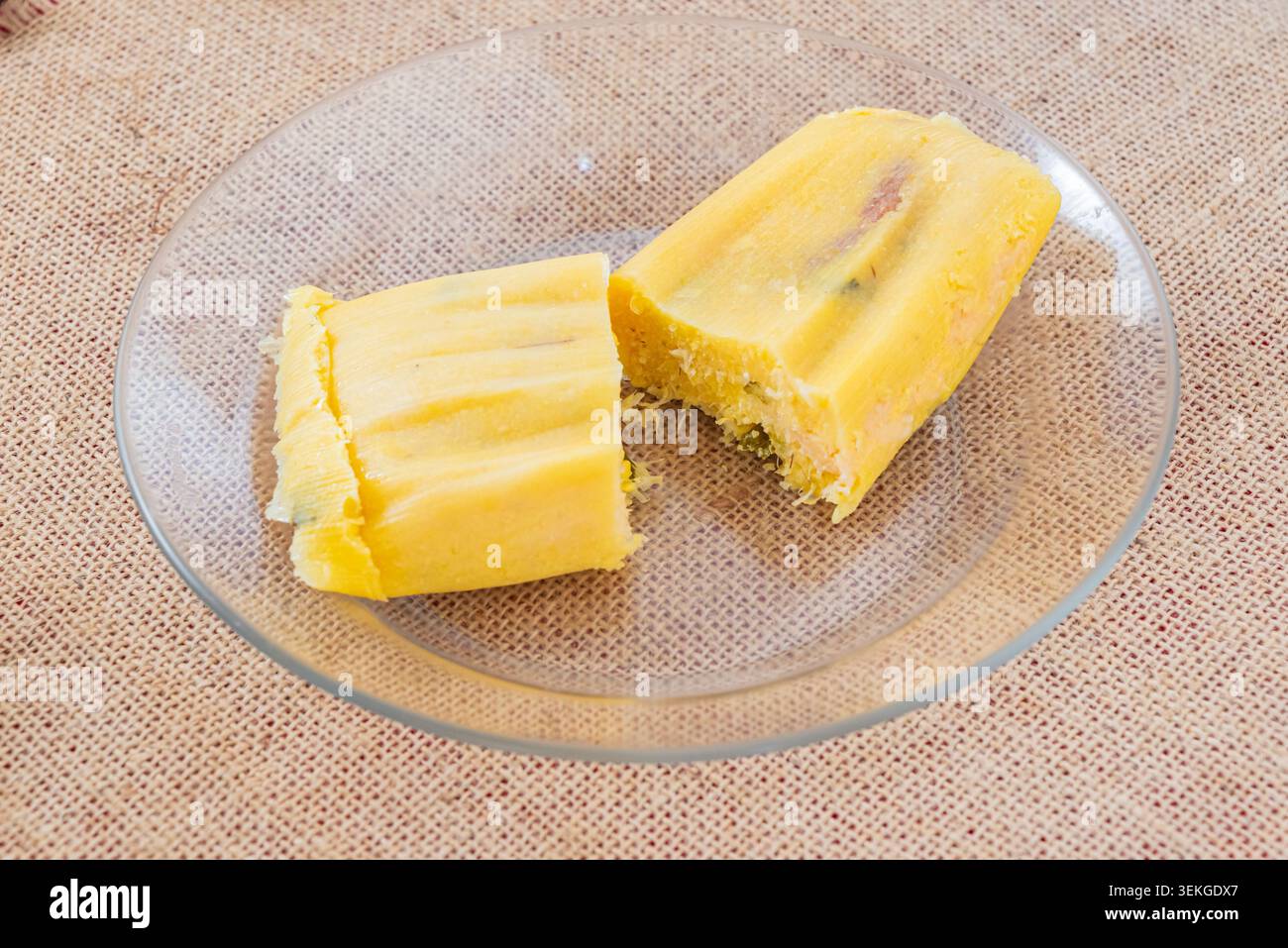 Pamonha, a traditional brazilian corn cake, served on glass plate over ...