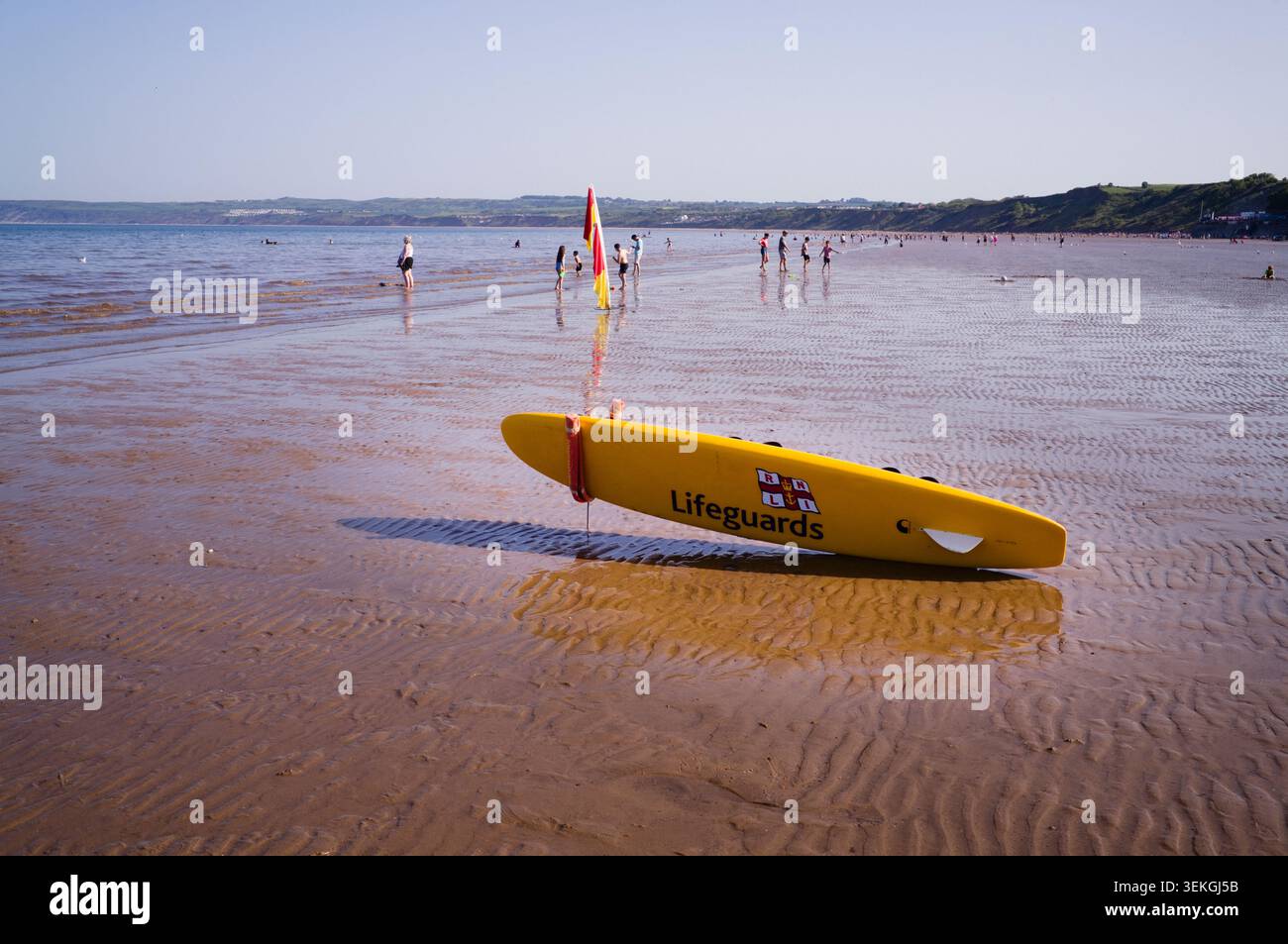 Bathers in the sea near RNLI surfboard at Filey beach, North Yorkshire ...