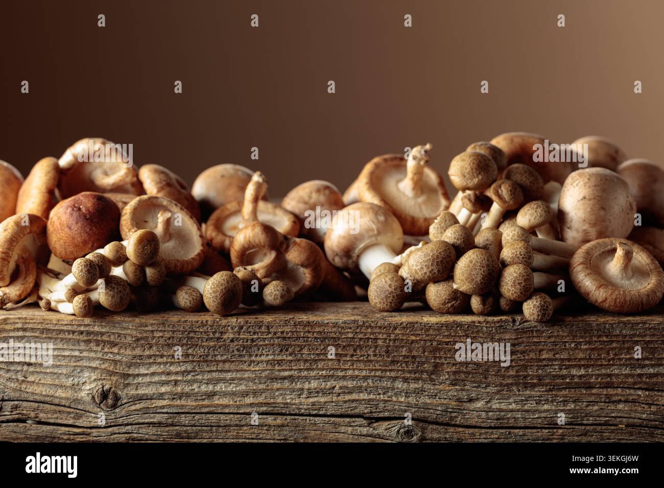 Fresh shiitake, champignon, and shimeji mushrooms on an old wooden ...