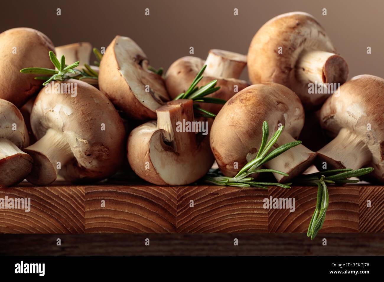 Mushrooms on a wooden cutting board. Champignon with rosemary. Copy ...