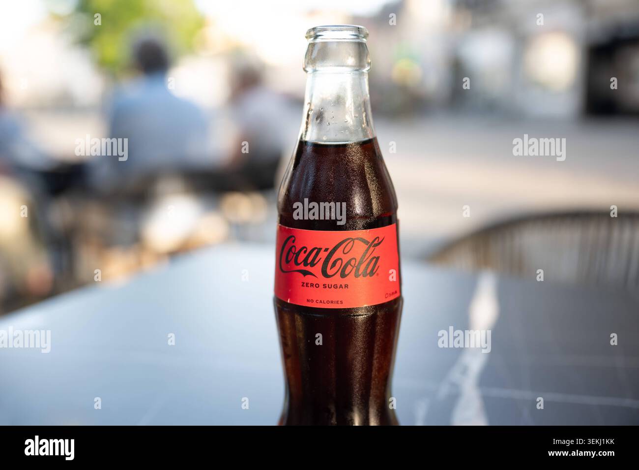 A classic glass bottle of Coca-Cola Zero stands on a table ...