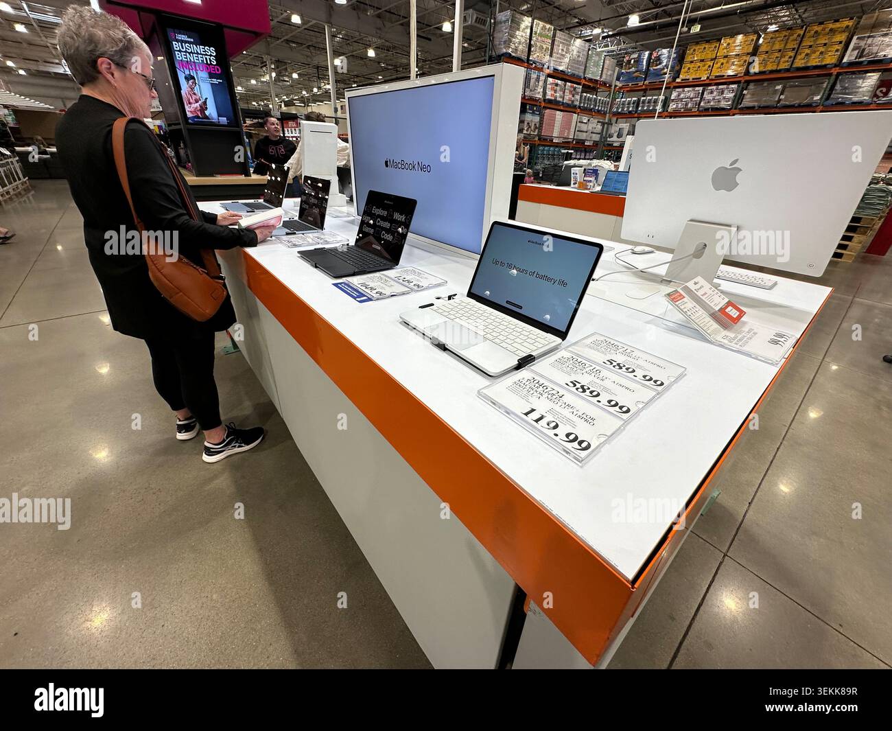 A shopper looks over Apple MacBook laptops on display in a Costco ...
