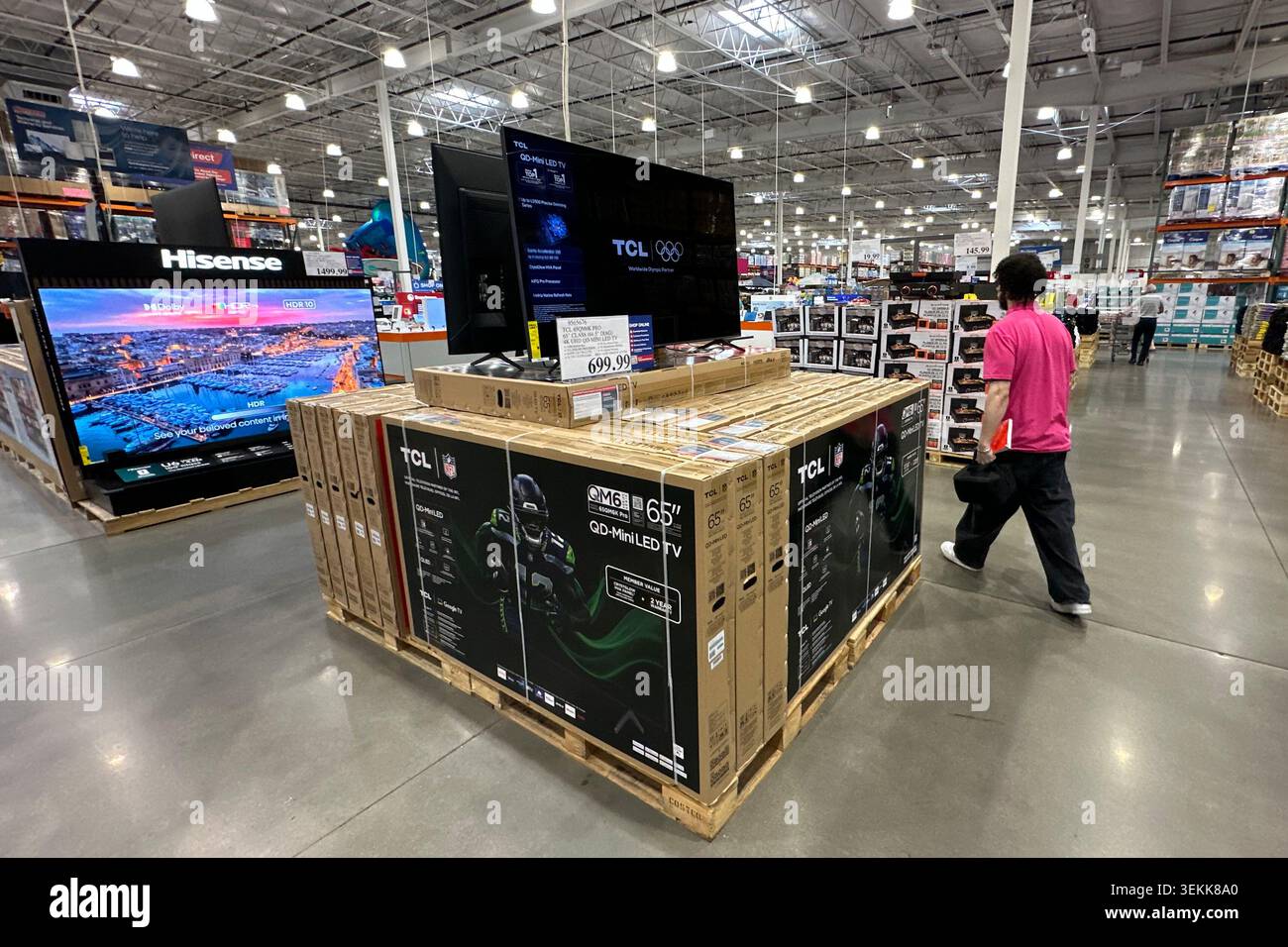 A shopper passes by big-screen televisions on display at a Costco ...