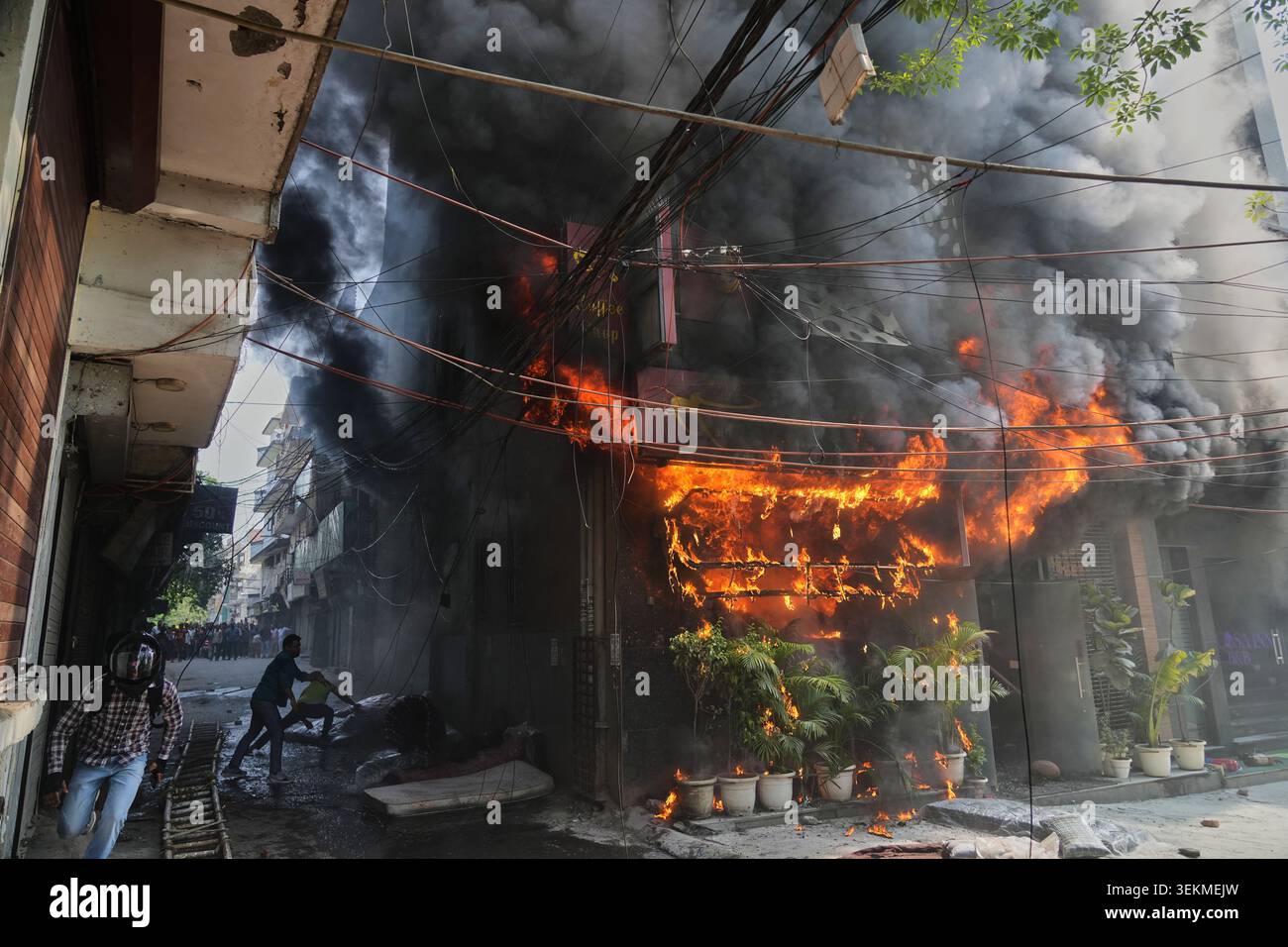 Local people attempt to douse a fire at a hotel in New Delhi, India ...