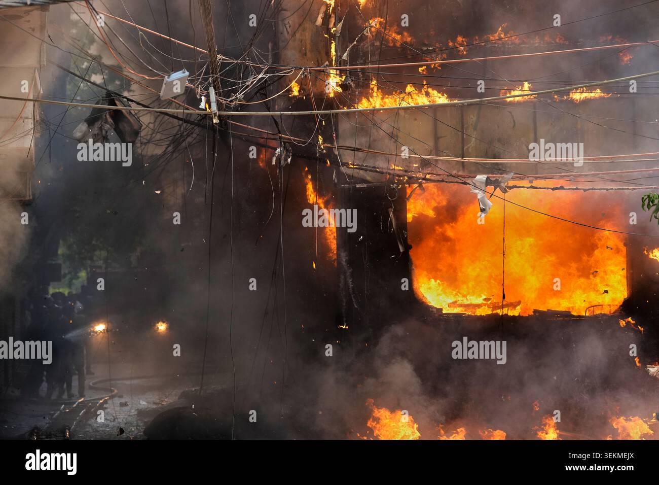 Fire officials douse a fire at a hotel in New Delhi, India, Wednesday ...