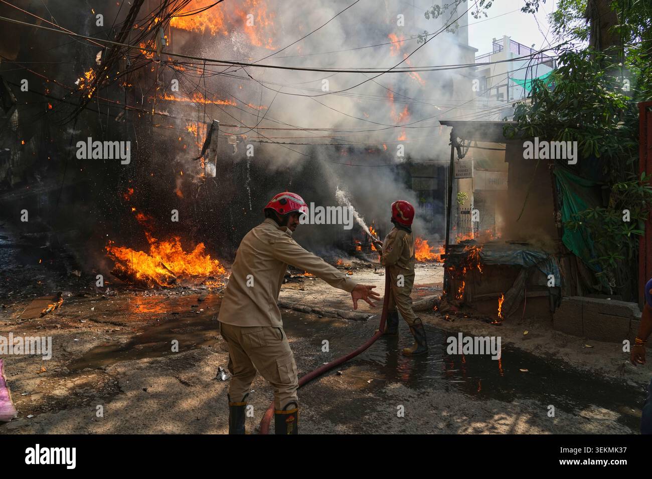 Firefighters douse a fire in a hotel in New Delhi, India, Wednesday ...
