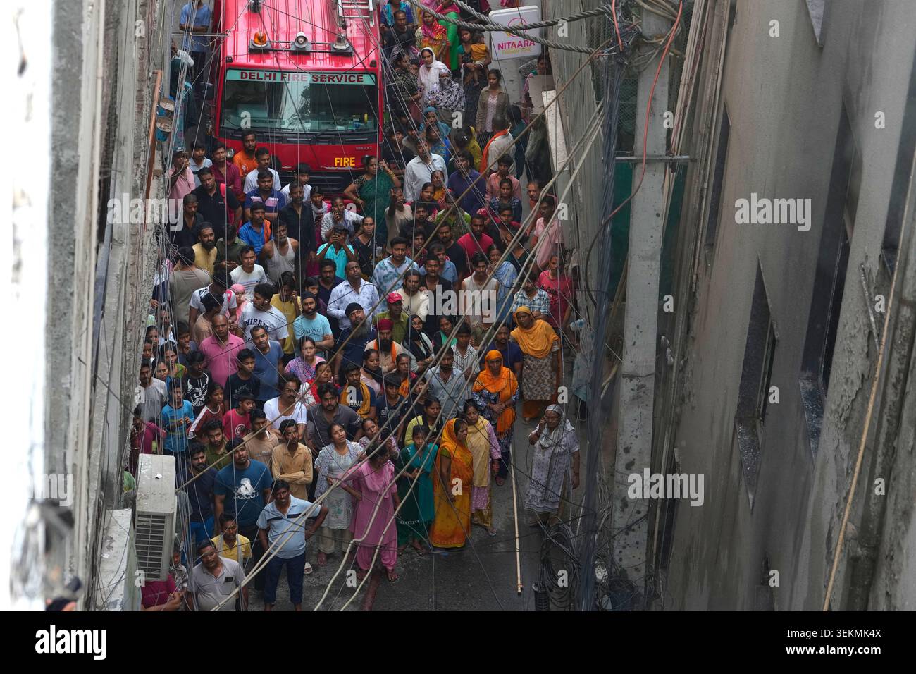 Locals and bystanders watch a hotel fire as firefighters work to douse ...