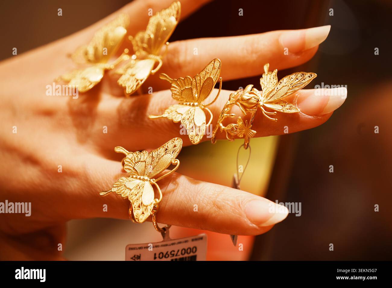 A staff member displays a butterfly-shaped gold ring at a gold store in ...
