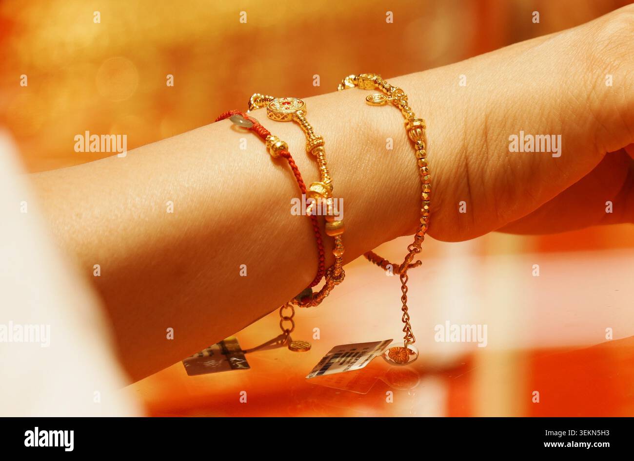A customer selects gold jewelry at a store in Hangzhou, east China's ...